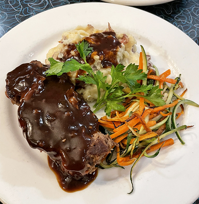 Meatloaf that doesn't apologize for being meatloaf&mdash;gloriously sauced, with mashed potatoes standing by for gravy duty.