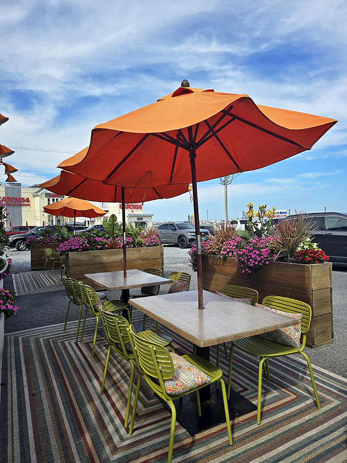 Outdoor seating that celebrates color therapy. Those orange umbrellas and lime-green chairs are serving joy before your food even arrives.