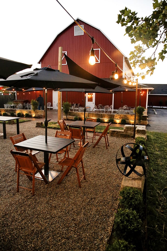 Outdoor seating under string lights transforms farm-to-table from concept to literal experience. Romance among the cornfields.