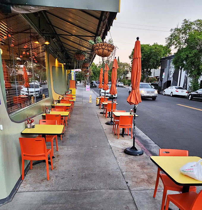 Sidewalk tables with bright orange chairs create the perfect stage for Los Angeles' favorite spectator sport: people-watching.