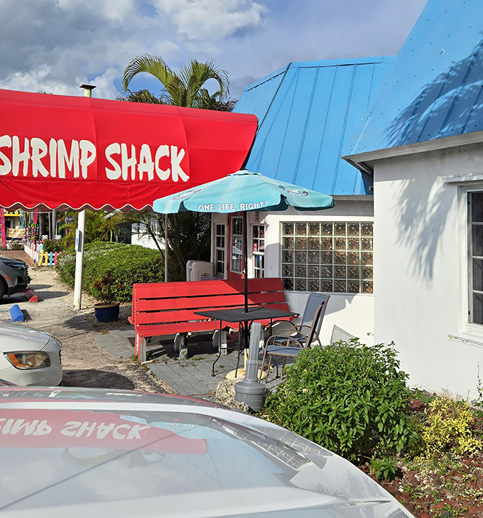 The cheerful exterior with its mix of red awning and blue roof captures the laid-back Keys vibe perfectly. That bench says "relax, you're on island time now." 
