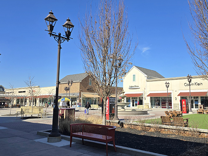 The village-style layout with old-fashioned lamp posts makes spending money feel charming instead of like a fluorescent mistake.