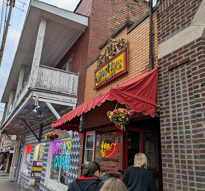 The approach to O'Betty's feels like discovering a secret society dedicated to hot dog perfection. That neon wiener sign is practically winking at you.