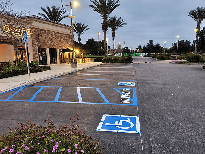 As dusk falls on the parking lot, the palm trees and lights create a surprisingly serene end to a day of retail conquest.