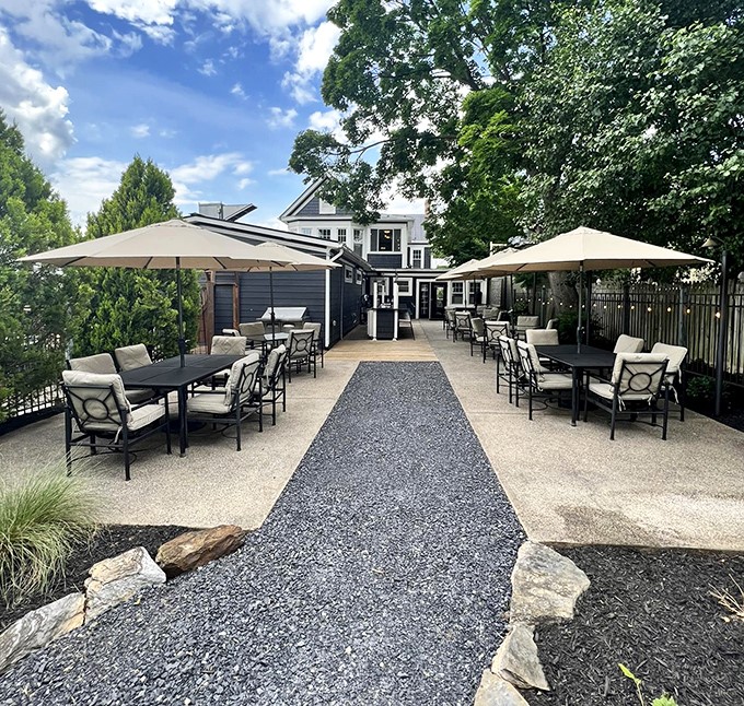 An elegant outdoor patio space where umbrellas stand guard against the sun. Al fresco dining that makes you wonder why you ever eat indoors when Virginia weather cooperates.