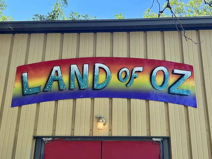 "LAND OF OZ" announces itself in rainbow splendor, promising technicolor adventures beyond those iconic red doors. The magic awaits inside!