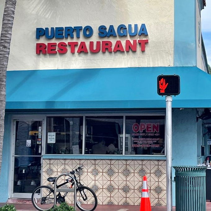 The neon sign glows like a lighthouse for hungry souls navigating the sea of South Beach pretension, promising authentic harbor within.