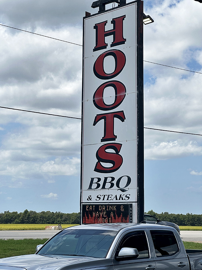 The roadside sign stands tall against the Arkansas sky, a barbecue lighthouse guiding hungry travelers home.