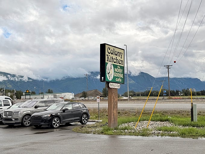 That roadside sign against mountain mist promises more than just food &ndash; it's a beacon of comfort for hungry travelers on the Glenn Highway.