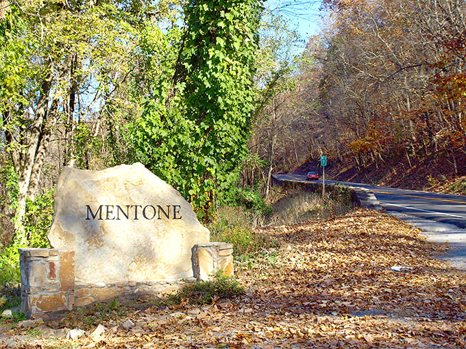 The stone Mentone welcome marker stands sentinel at the town's entrance, autumn leaves gathering at its base. Your official invitation to slow down and stay awhile.