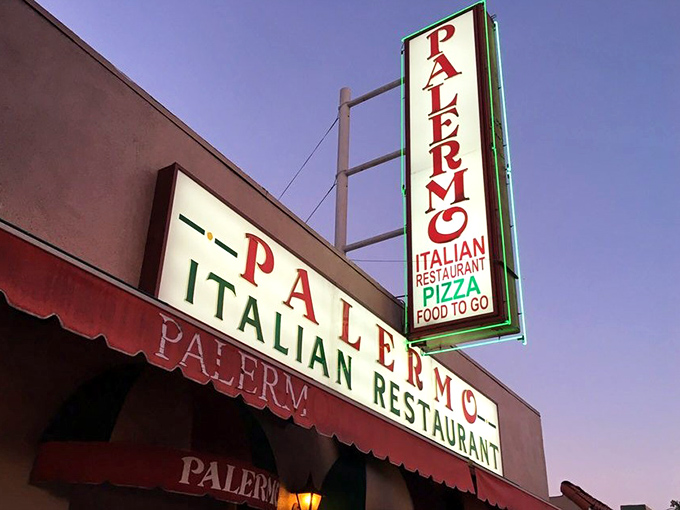 The neon sign glows like a beacon in the night, guiding hungry souls to their pasta salvation.