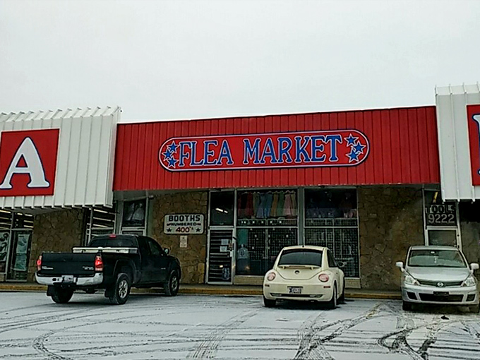 The red and white "FLEA MARKET" sign stands as a beacon of bargain hope. Even in winter, it promises warm deals inside.