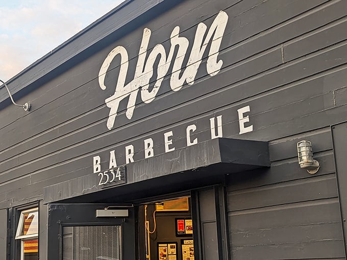 That bold white lettering against black isn't just signage&mdash;it's the first chapter in a story that continues with smoke, fire, and flavor.