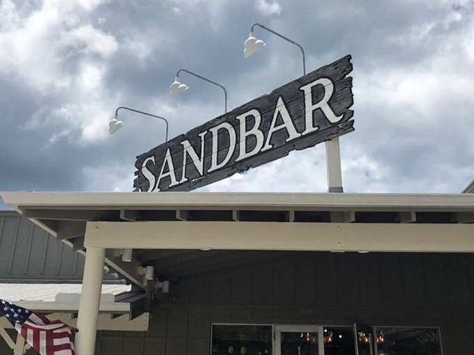 The Sandbar sign against moody skies&mdash;a beacon for hungry travelers seeking that perfect combination of fresh seafood and Florida charm.