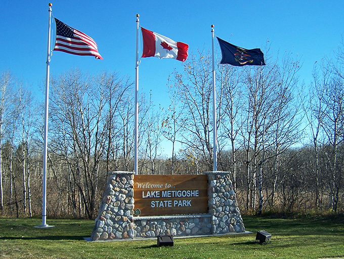 Three flags, endless possibilities. This welcoming stone monument stands as a friendly reminder that adventure recognizes no borders.
