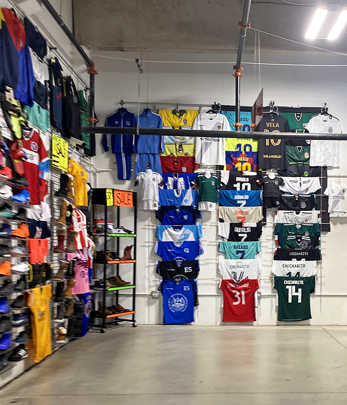 Soccer jersey paradise where team loyalties hang side by side in rare peaceful coexistence, unlike their passionate fans on game day.
