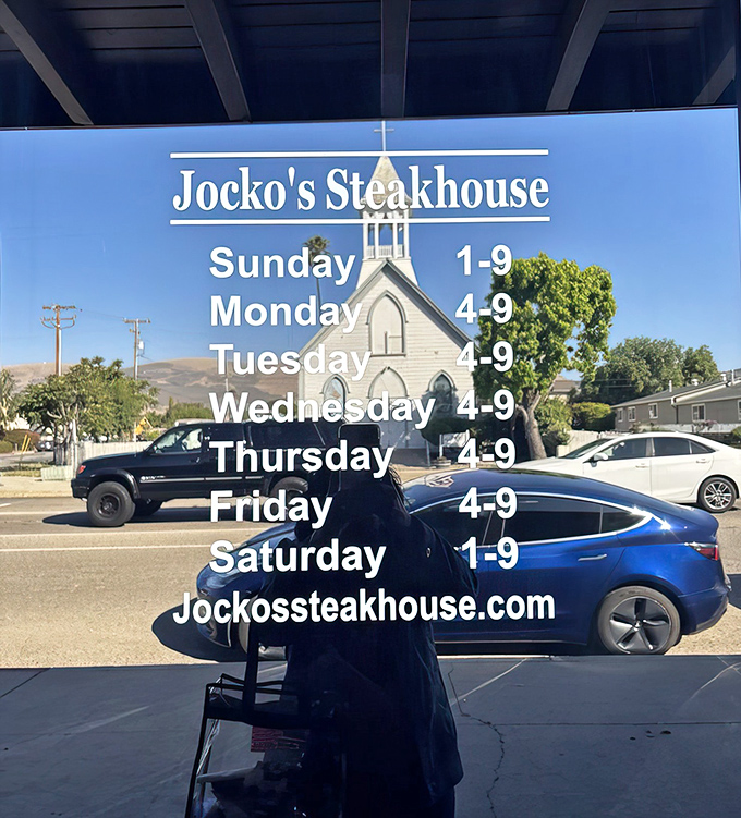 The hours posted like a friendly invitation. That church in the background is appropriate&mdash;for many meat lovers, this place is their place of worship.