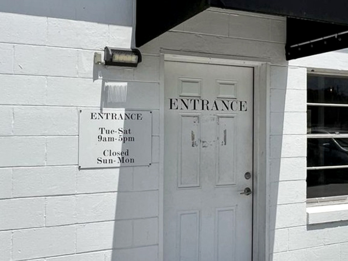 The gateway to treasure hunting announces its hours with no-nonsense clarity. Tuesday through Saturday, the adventure awaits behind this white door.