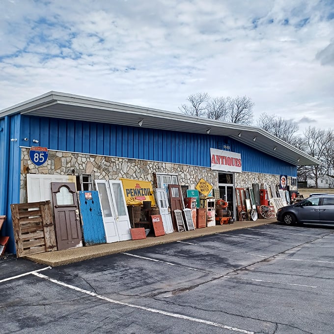 The storefront's eclectic display hints at wonders inside – where else can doors, signs, and memories share sidewalk space?