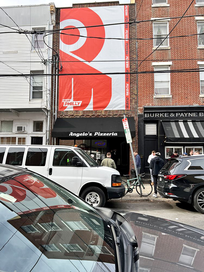 The red banner announces your arrival at a Philadelphia institution. This street view represents the beginning of your flavor journey.
