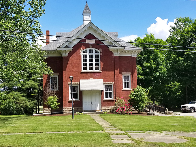 The town hall's stately red brick exterior and arched window suggest this community takes civic matters seriously, even when those matters involve populations smaller than most apartment buildings.