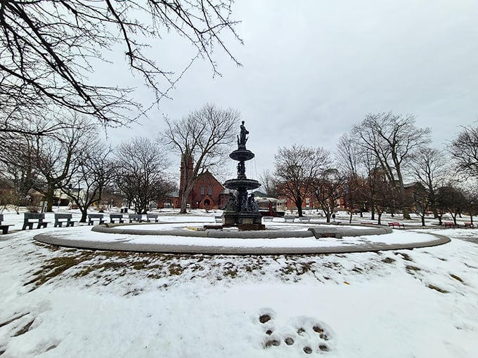 Taylor Park's fountain stands sentinel through winter's quiet embrace, like a stoic grandfather waiting patiently for spring's return.