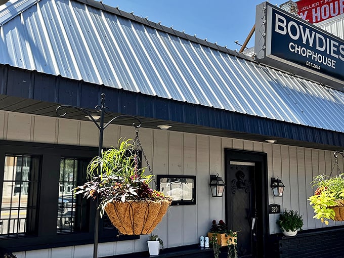 Bowdie's Chophouse exterior beckons with its blue metal roof and hanging flower baskets &ndash; simple outside, steak magic inside!