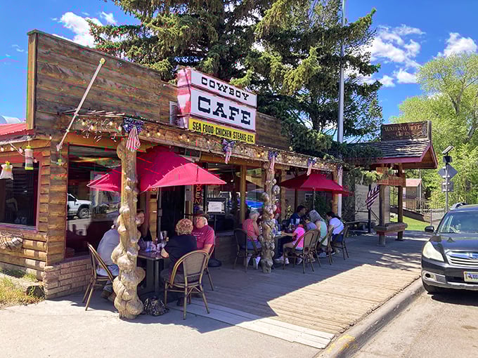 The Cowboy Cafe's rustic log cabin exterior isn't just Instagram-worthy&mdash;it's a time machine to the Wild West with red umbrellas!