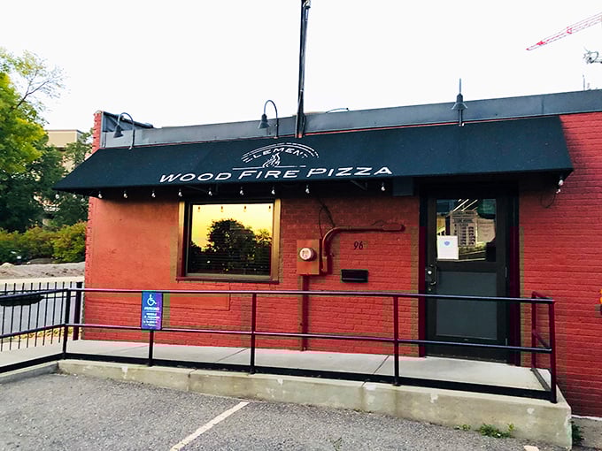 That red brick facade whispers promises of wood-fired perfection waiting inside Wood Fire Pizza.