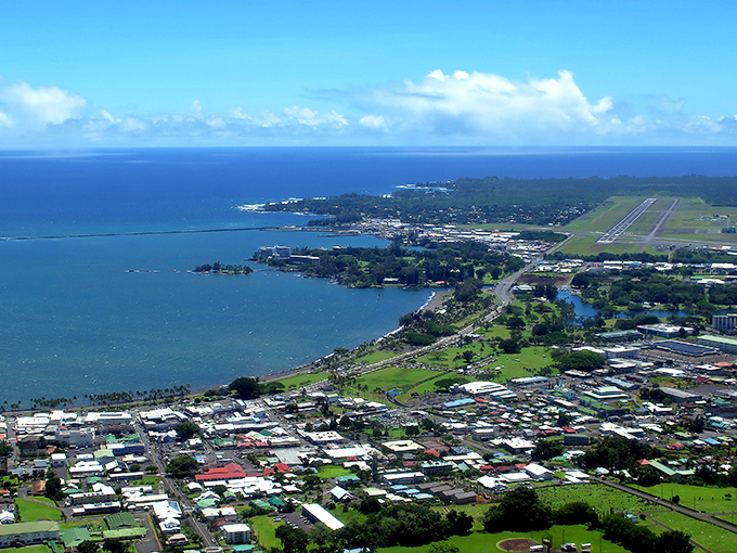 Aerial paradise! Hilo's stunning coastline unfolds like nature's welcome mat, with the airport runway promising adventures just a short flight away.