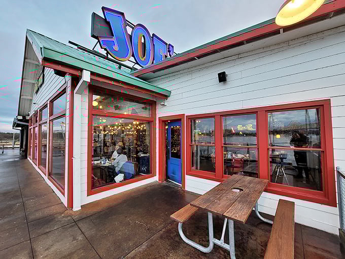 Joe's Crab Shack's colorful waterfront location features bright red trim and outdoor seating where diners enjoy river views with their seafood feasts.