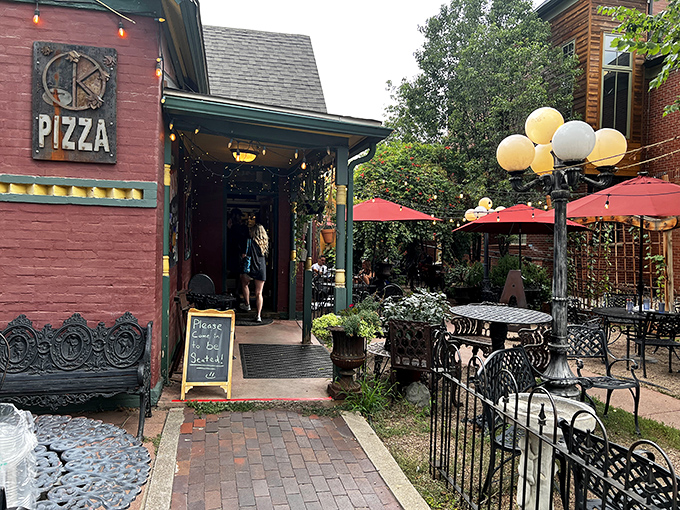 The charming red exterior of Kaos Pizzeria beckons like a secret garden of pizza delights. Those string lights promise magic after sunset.