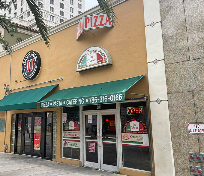Mario the Baker's yellow storefront promises authentic Italian goodness. That neon "OPEN" sign might as well say "Pizza Paradise Ahead!"