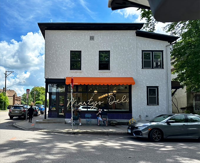 Marty's Deli stands proud on a Minneapolis corner, its orange awning like a beacon for sandwich lovers seeking their next great bite.