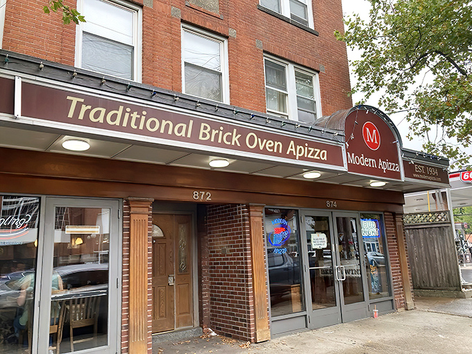 Modern Apizza's brick facade isn't just charming&mdash;it's a portal to New Haven pizza paradise. That "Traditional Brick Oven" sign promises crispy, charred perfection inside.