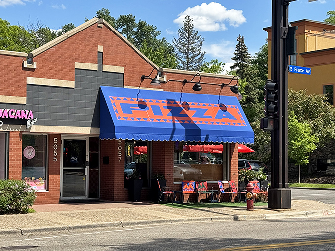 The bright blue awning of Mothership Pizza Paradise stands out like a pizza oasis on this Minneapolis street corner.