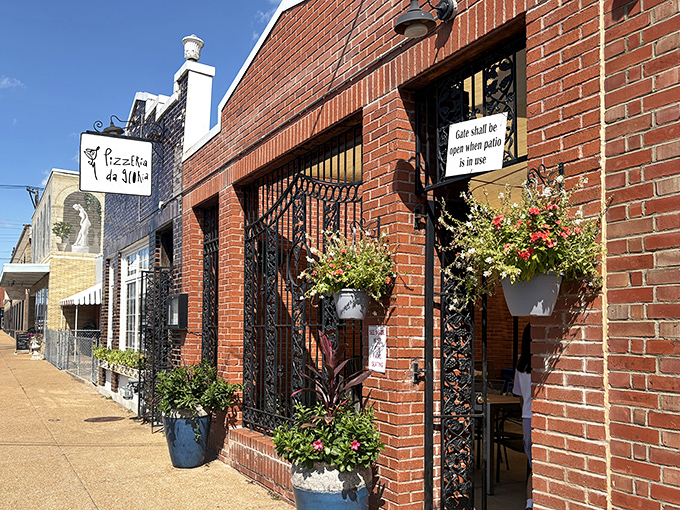 The charming brick facade of Pizzeria da Gloria beckons with wrought iron gates and colorful flower pots. Pizza paradise awaits behind those doors!