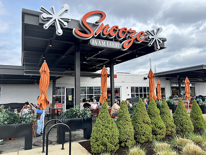 Snooze's vibrant orange umbrellas and modern signage promise a breakfast experience that's anything but sleepy.