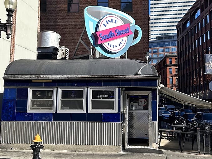 South Street Diner's iconic blue exterior and giant coffee cup sign stand as a beacon for late-night comfort food seekers in Boston's urban landscape.