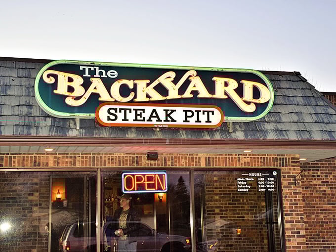 The Backyard Steak Pit's glowing sign promises a homecoming. Like finding that perfect neighborhood spot where everybody might know your name.