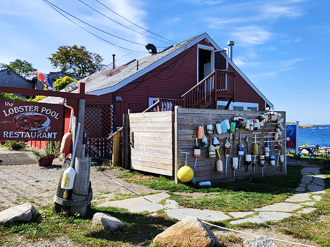 The Lobster Pool's charming red exterior sits right on the water, with colorful buoys decorating the walls and ocean views nearby.
