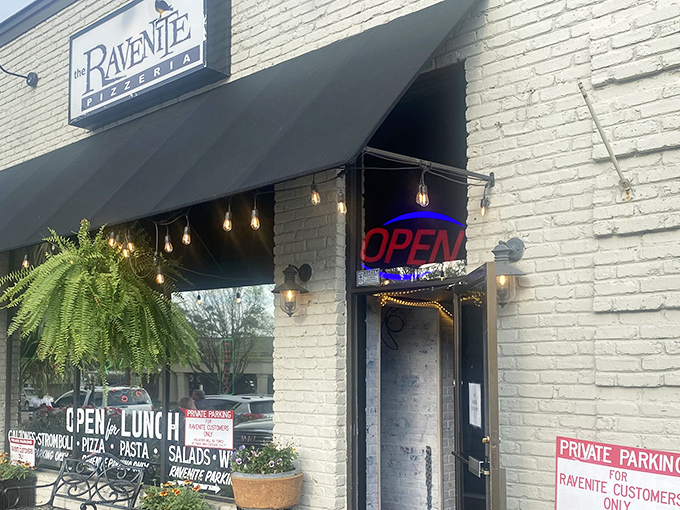 The Ravenite's charming brick facade and twinkling lights promise Italian magic hiding behind that unassuming "OPEN" sign.