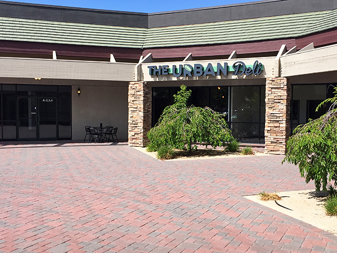 The Urban Deli's welcoming storefront promises sandwich adventures beyond the ordinary brick pathway.