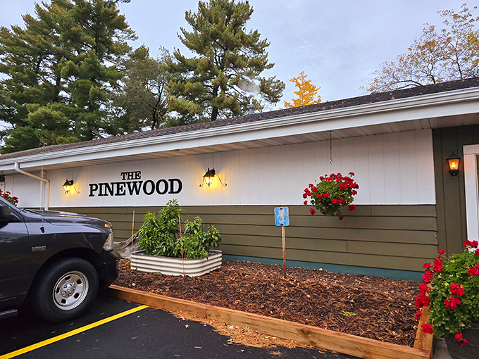 The unassuming exterior of Pinewood Supper Club stands like a culinary speakeasy among towering pines, promising delicious secrets within.