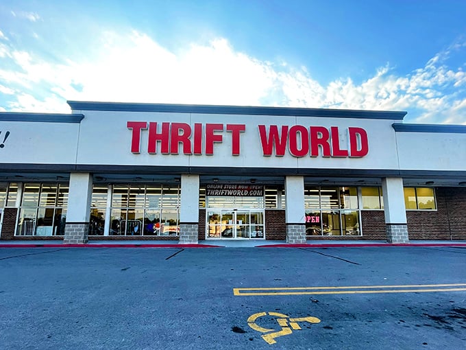 The bright red "THRIFT WORLD" sign beckons like a lighthouse for bargain hunters. This treasure trove awaits with endless possibilities inside!