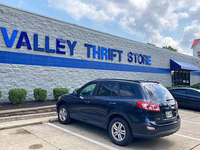 The blue sign of Valley Thrift Store beckons like a retail lighthouse, promising treasures within those unassuming walls.