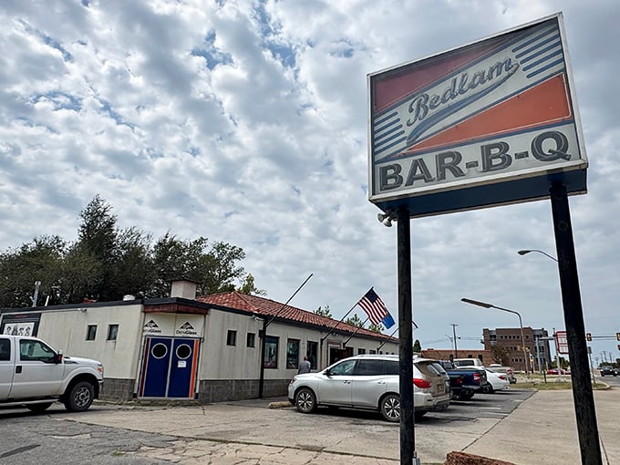 Bedlam's iconic sign stands tall against the Oklahoma sky, a beacon for barbecue pilgrims seeking smoky salvation.