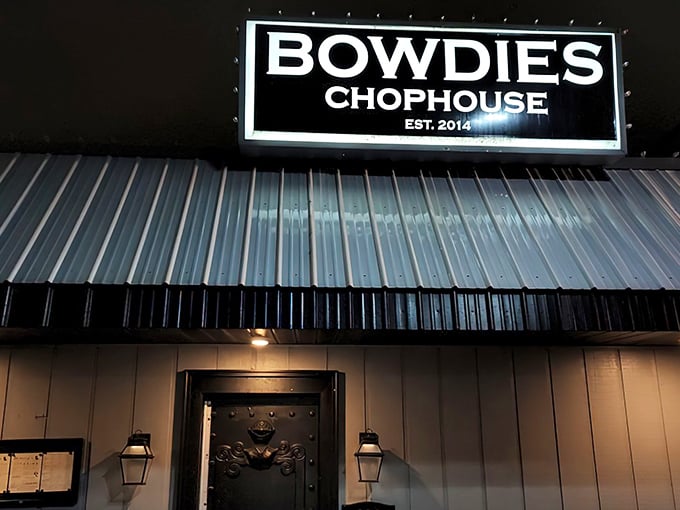 The illuminated Bowdie's Chophouse sign glows like a beacon in the night, guiding hungry souls to steak paradise.