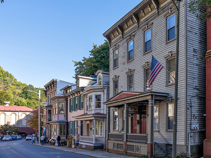 Historic Jim Thorpe's main street invites visitors to stroll past beautifully preserved buildings. American flags flutter in the breeze as the town showcases its 19th-century architectural splendor.