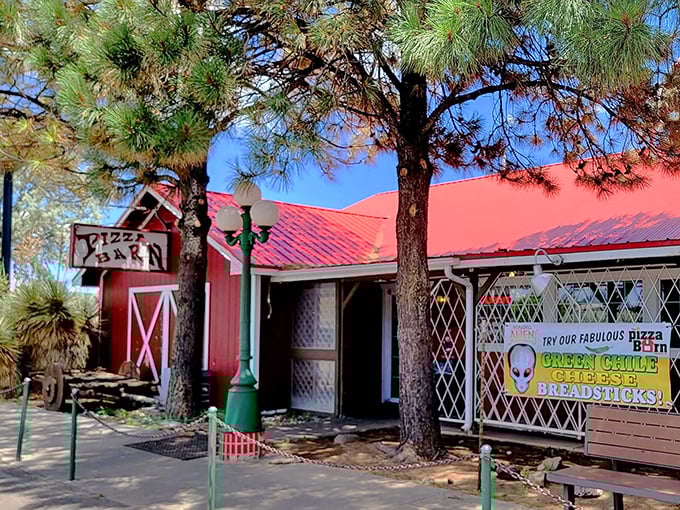 Look for the charming barn-red building with the rustic sign. Pizza paradise awaits behind those doors!